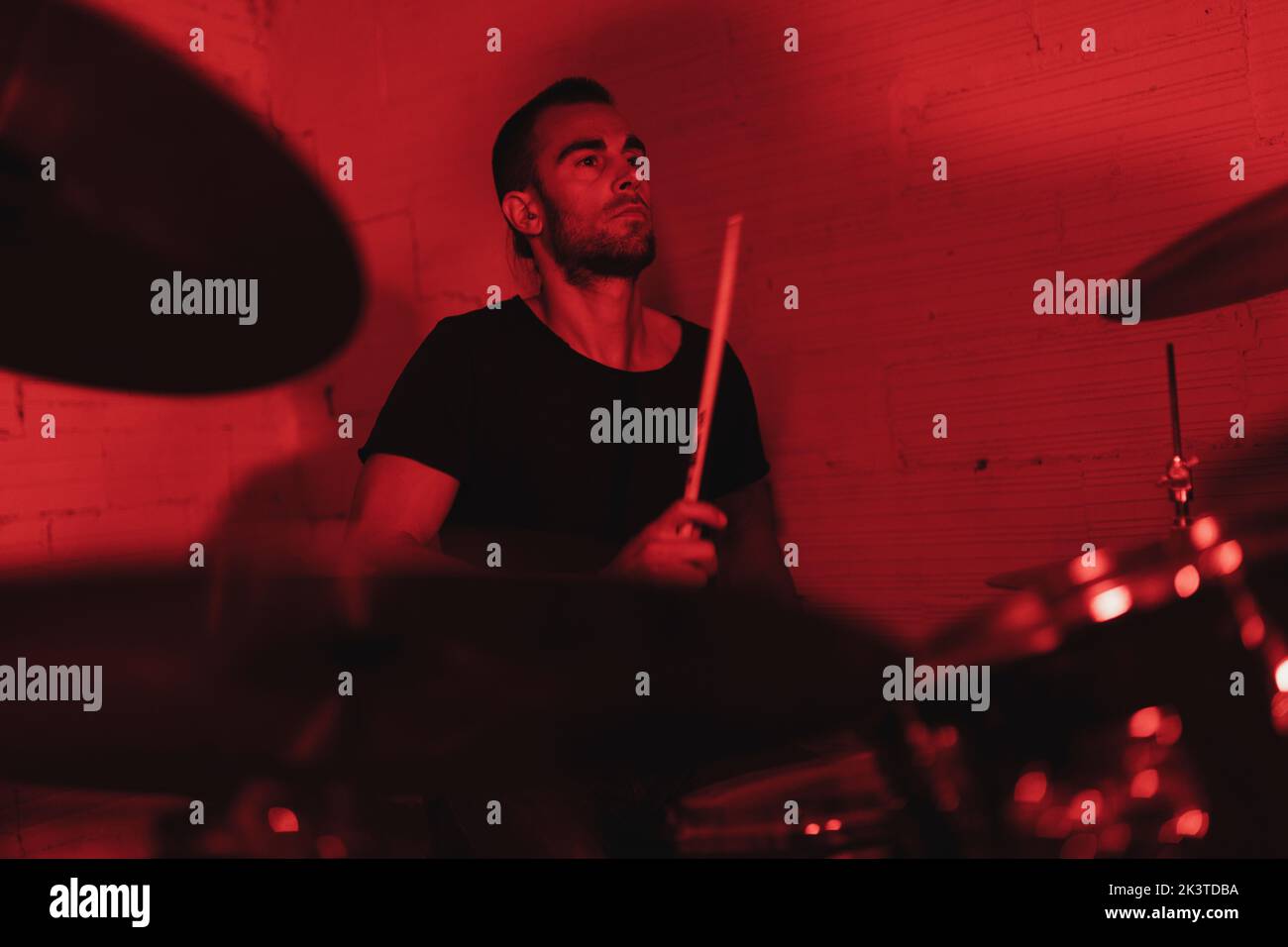 Group of musicians playing in red neon lights at music studio Stock ...