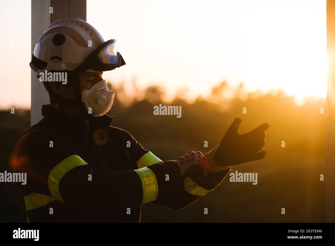 Firefighter getting dressed to start work disinfecting a building Stock ...