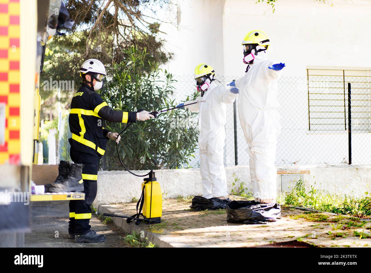 Firefighter disinfecting his colleagues' uniforms after cleaning ...