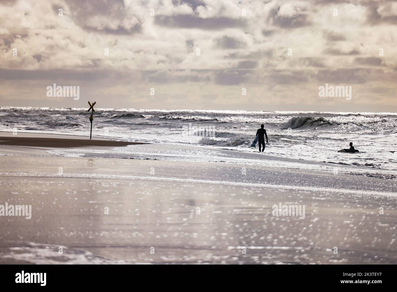 Westerland, Germany. 28th Sep, 2022. Surfers stand at the beach on the ...
