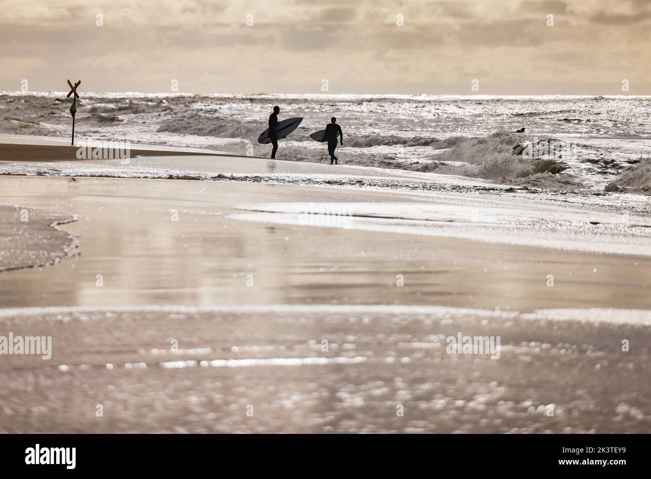 Westerland, Germany. 28th Sep, 2022. Surfers stand at the beach on the ...