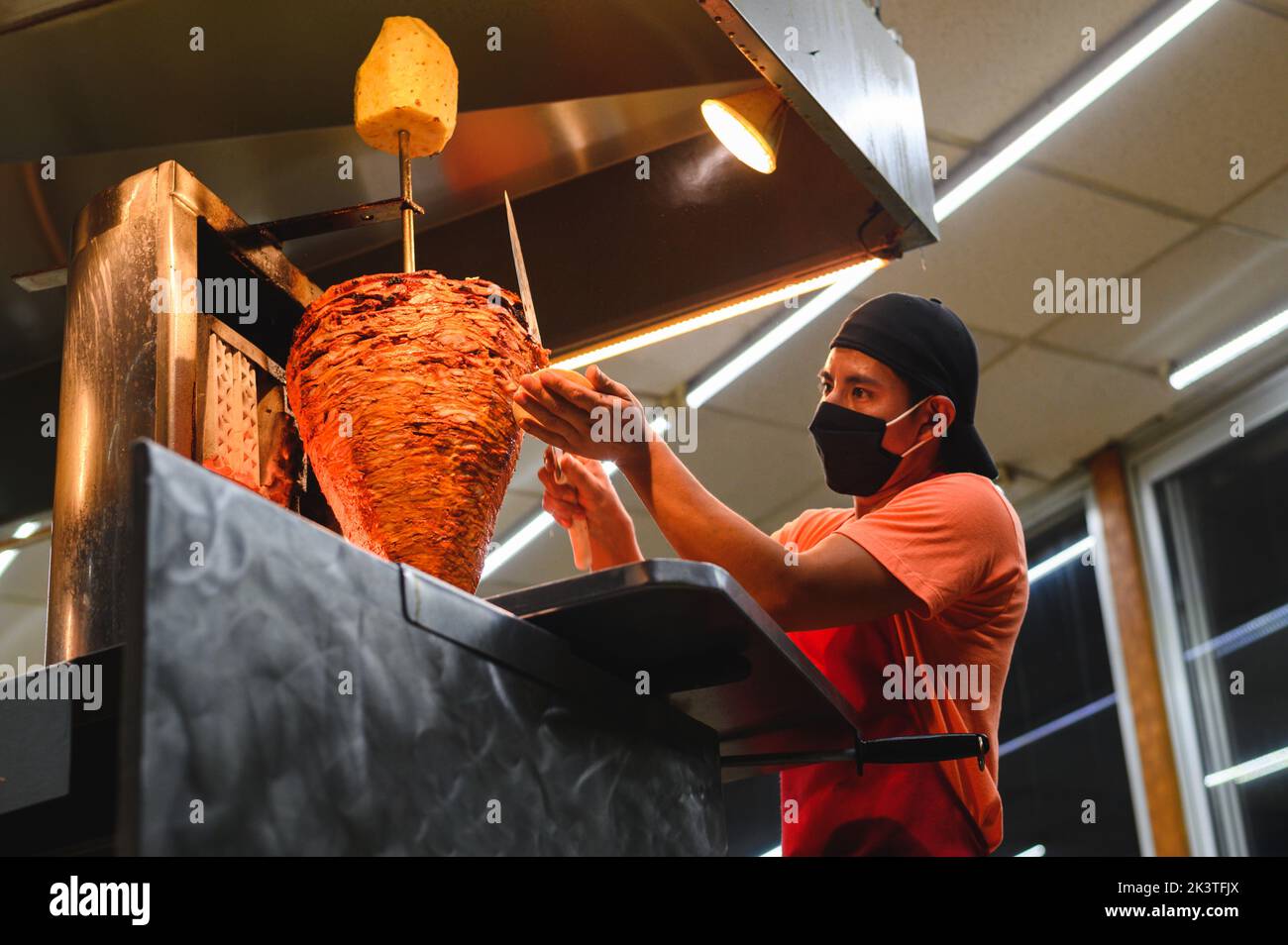 Ethnic male cook in cloth face mask with tortilla against vertical ...