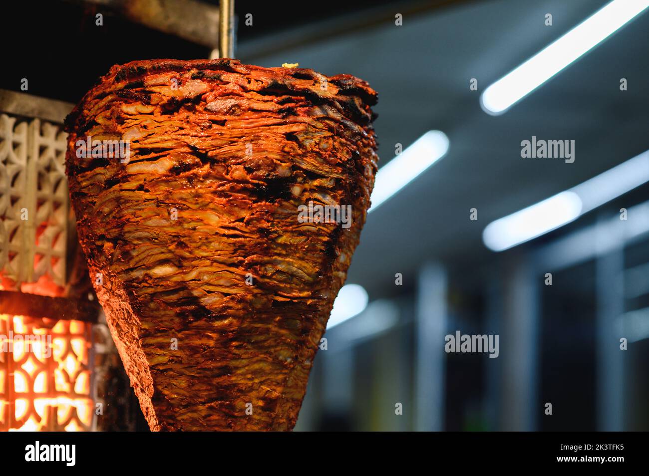 Vertical broiler with tasty meat against shiny lights in restaurant ...