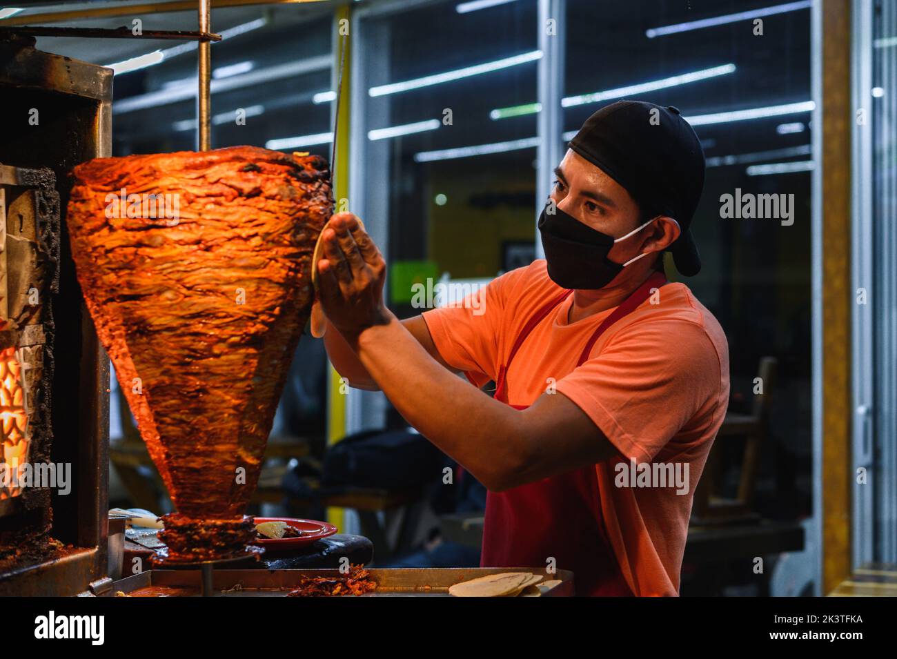 Ethnic male cook in cloth face mask with tortilla against vertical ...