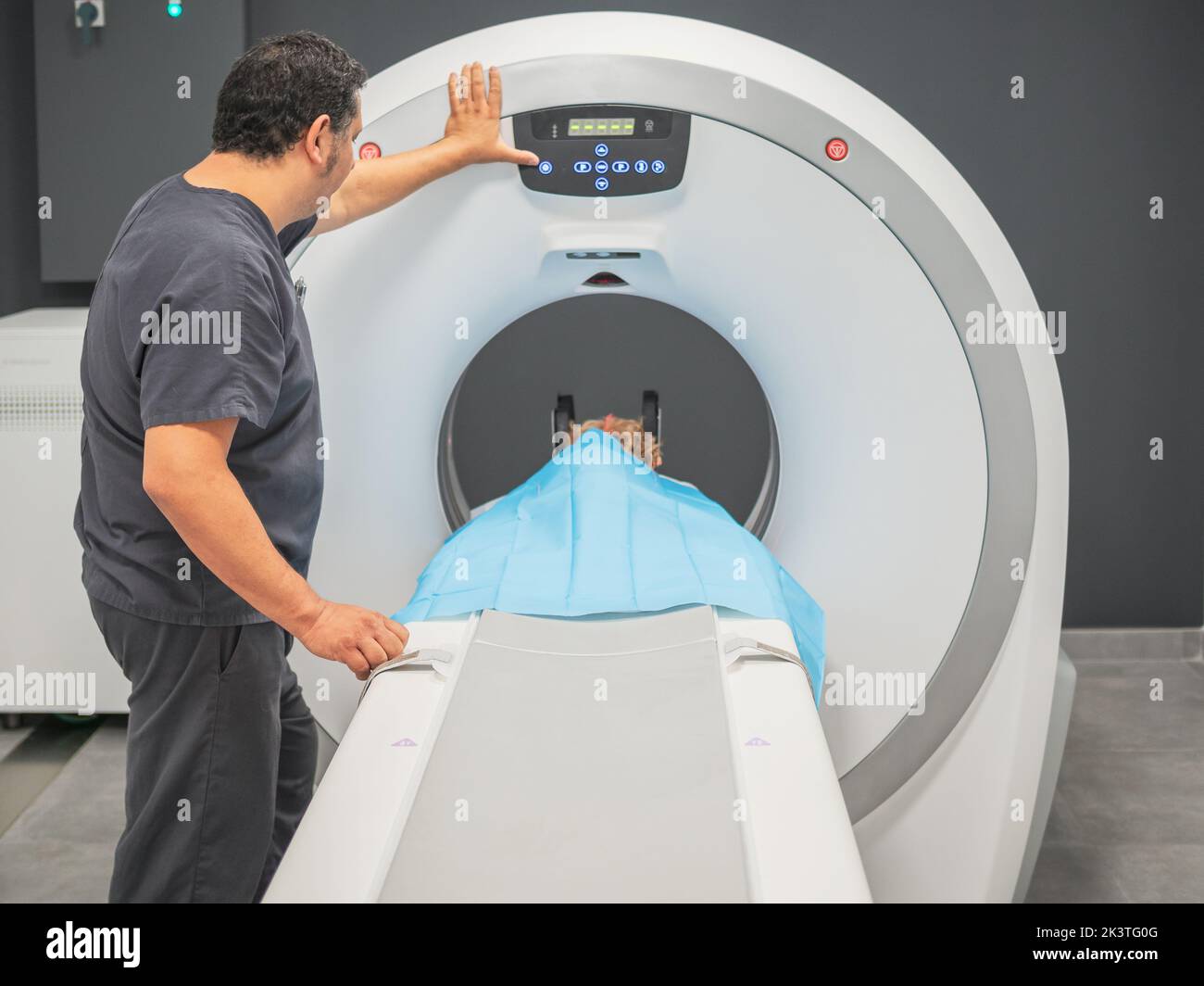 Side view of adult man operating MRI scanner during pet examination in ...