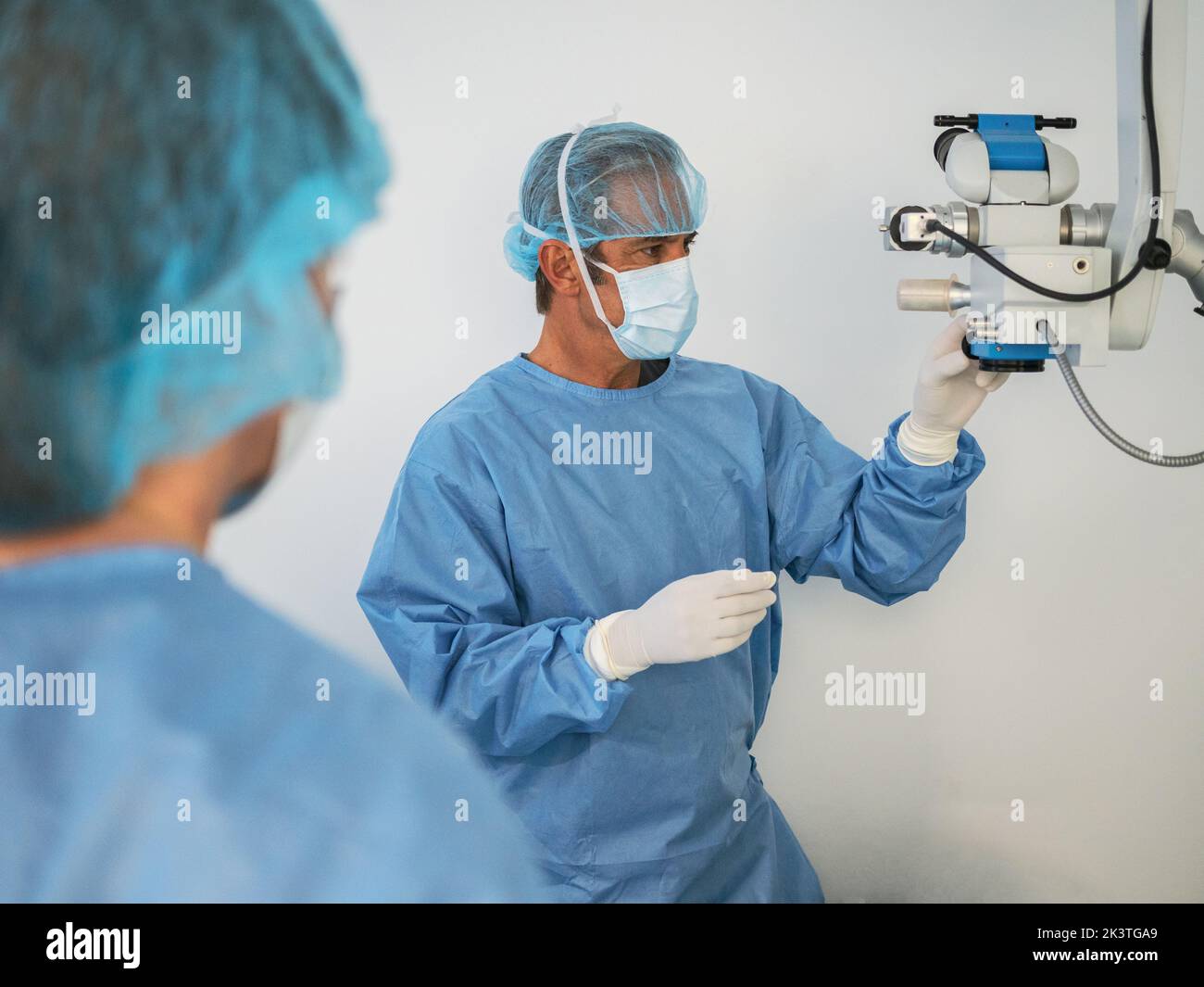 Adult man in mask and medical uniform checking professional operating ...