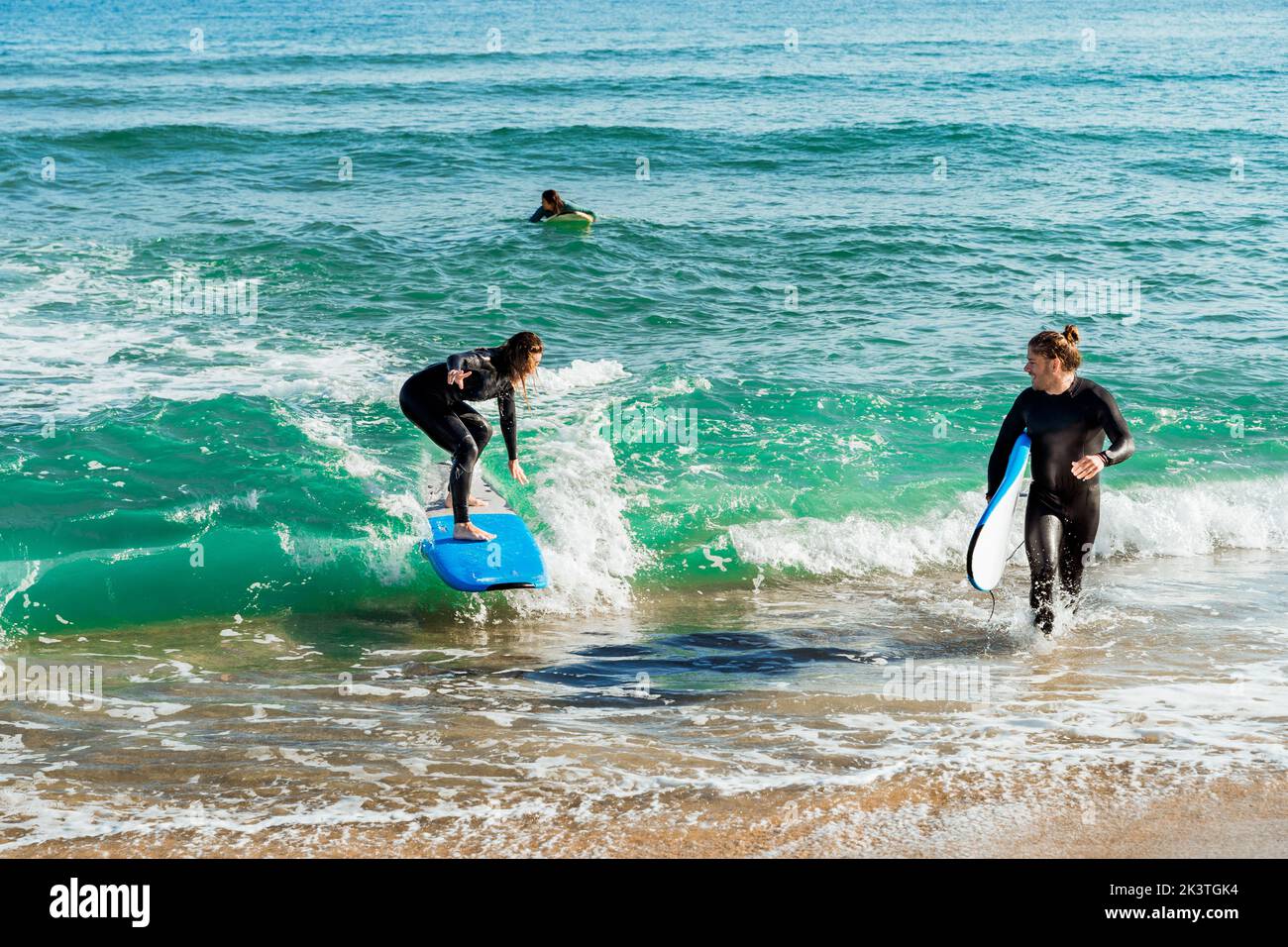 Young woman balancing on surfboard on ocean waves while practicing ...