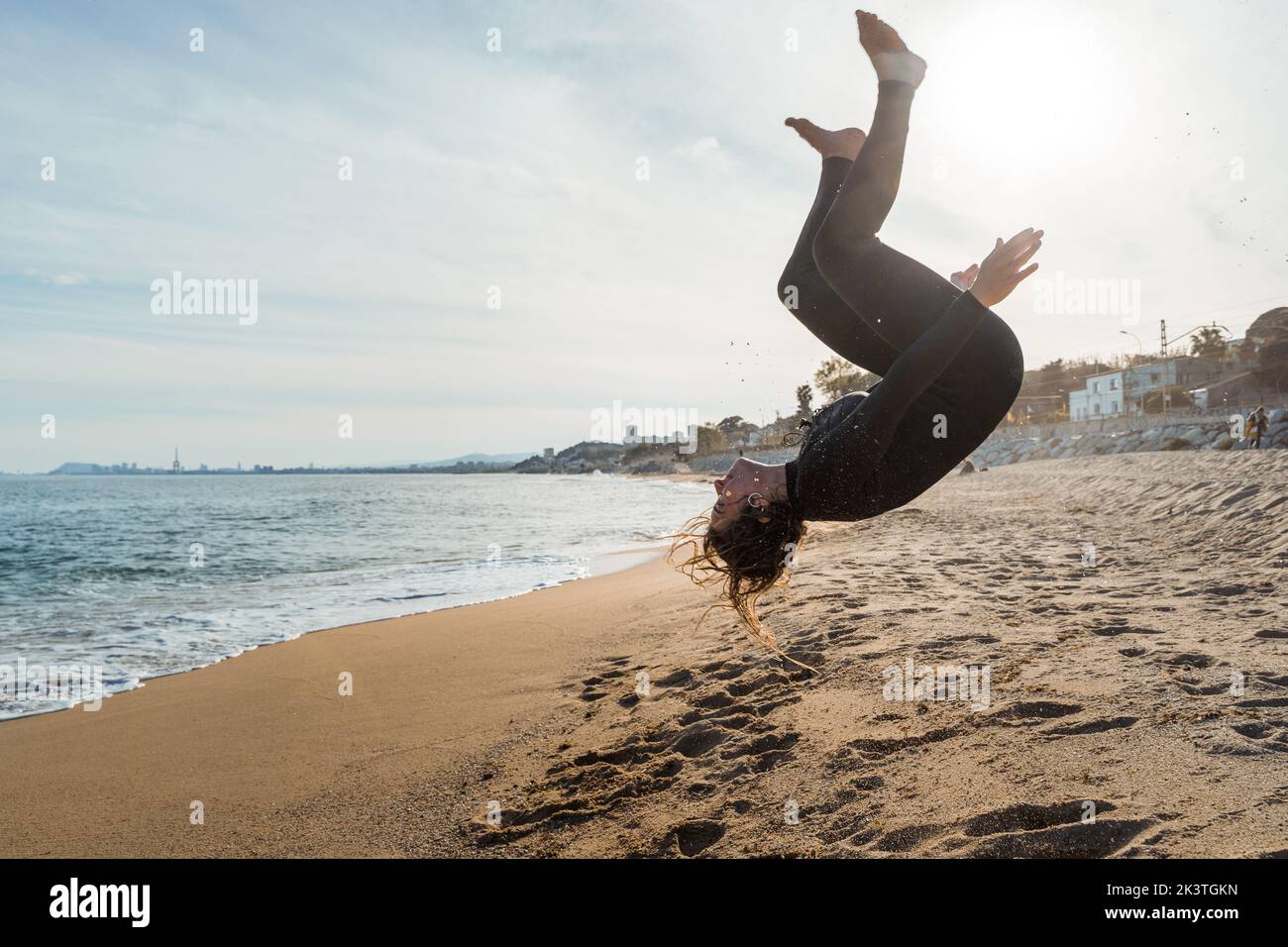 Full body side view of active young female in wetsuit performing ...