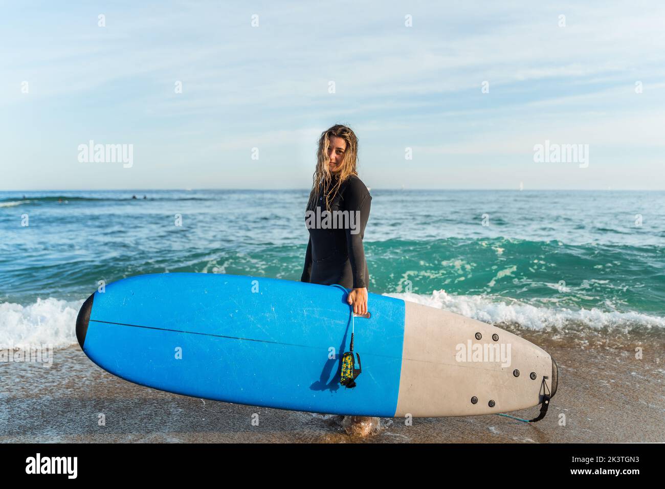 Side view full length of unrecognizable female surfer in wetsuit ...