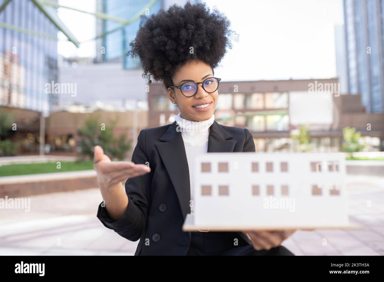 Content African American female architect in suit showing model of ...