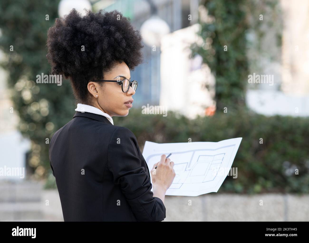 Back view of determined African American female architect in suit ...
