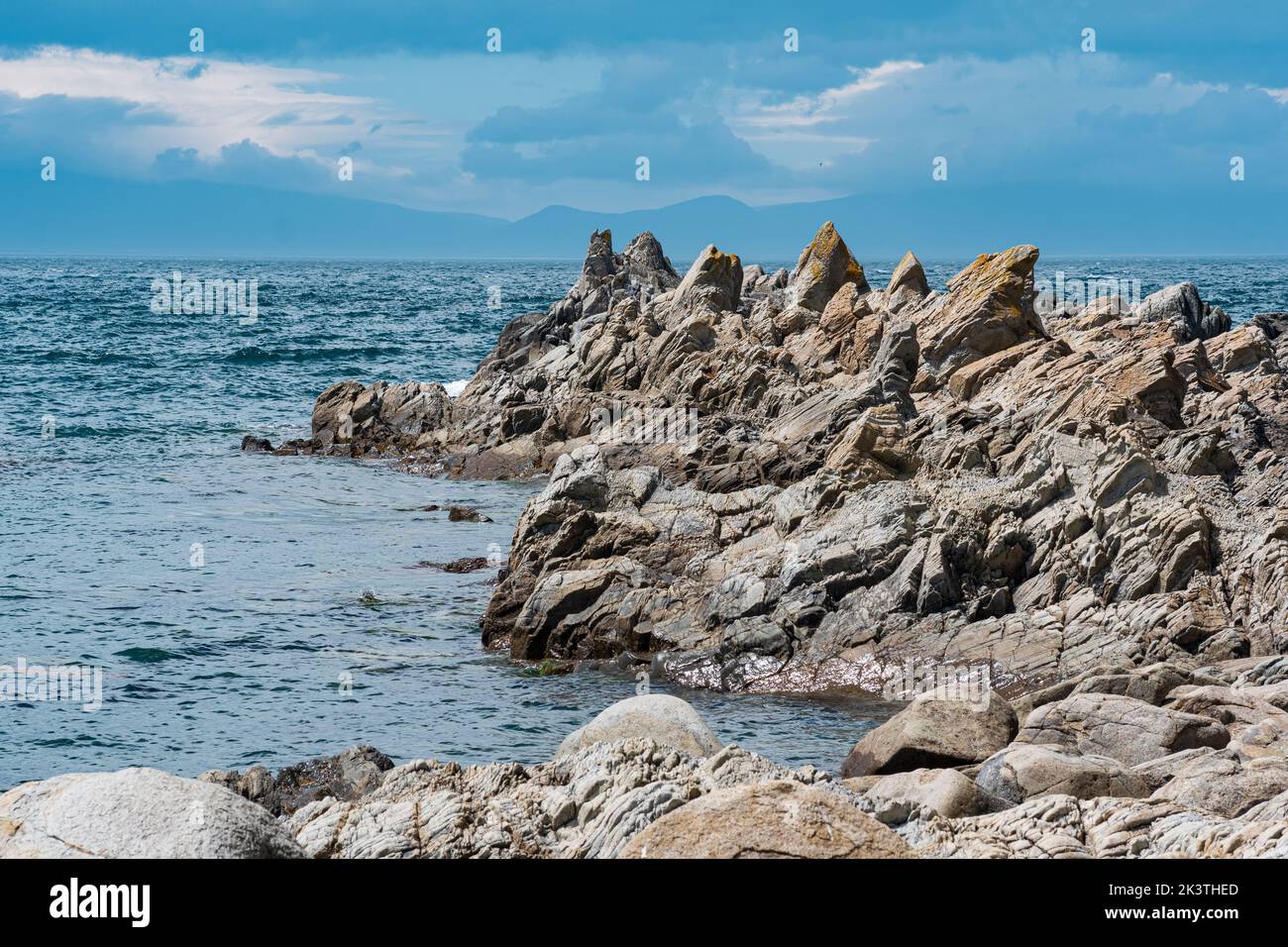 sharp jagged basalt rocks on the sea coast Stock Photo - Alamy