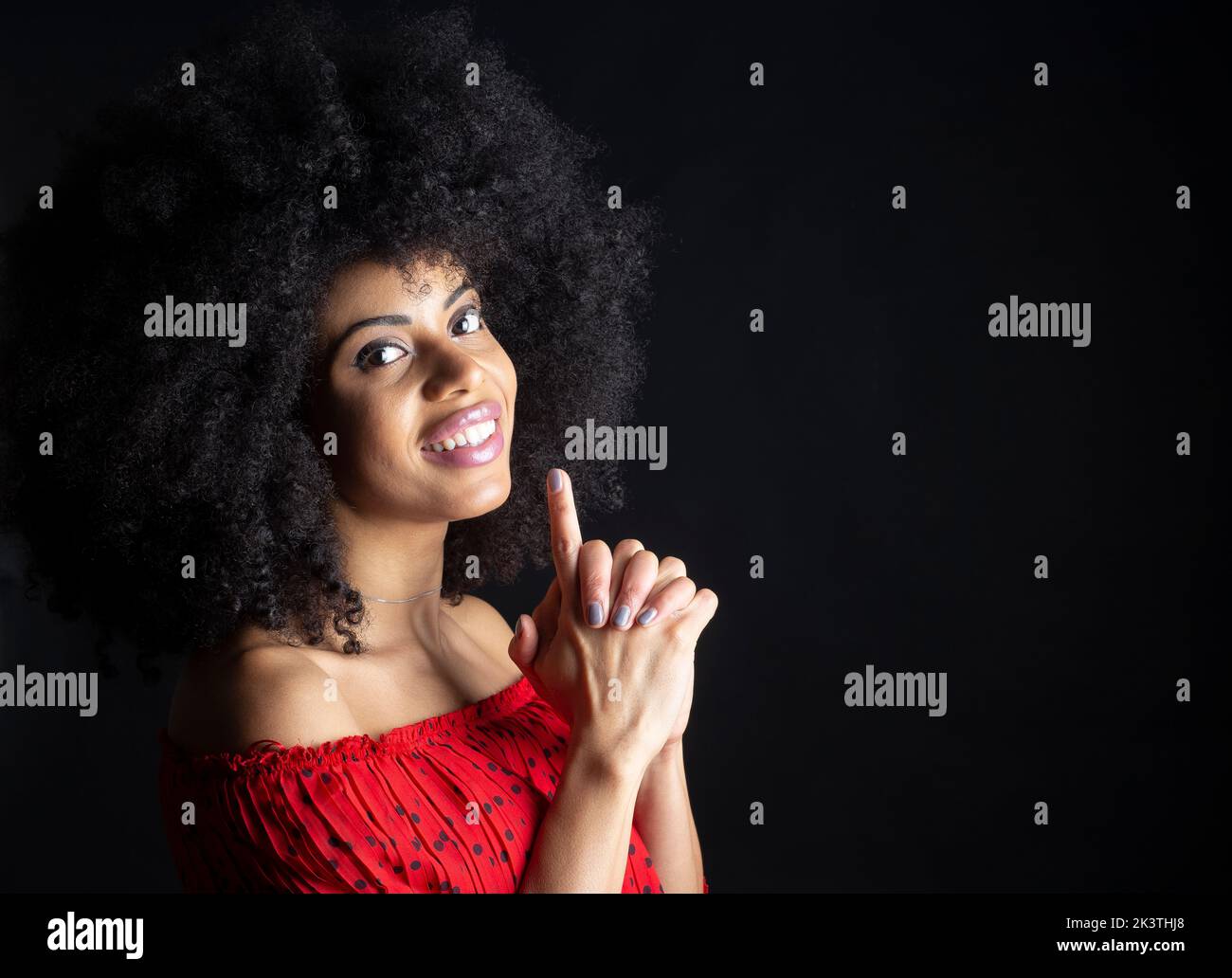 Side view of young Cuban female with Afro hairstyle showing silence ...