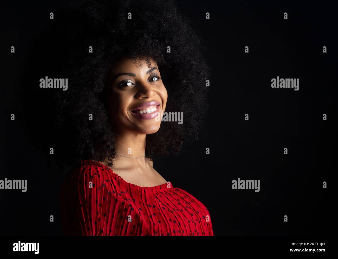 Side view of cheerful young ethnic female with afro hair in ornamental ...
