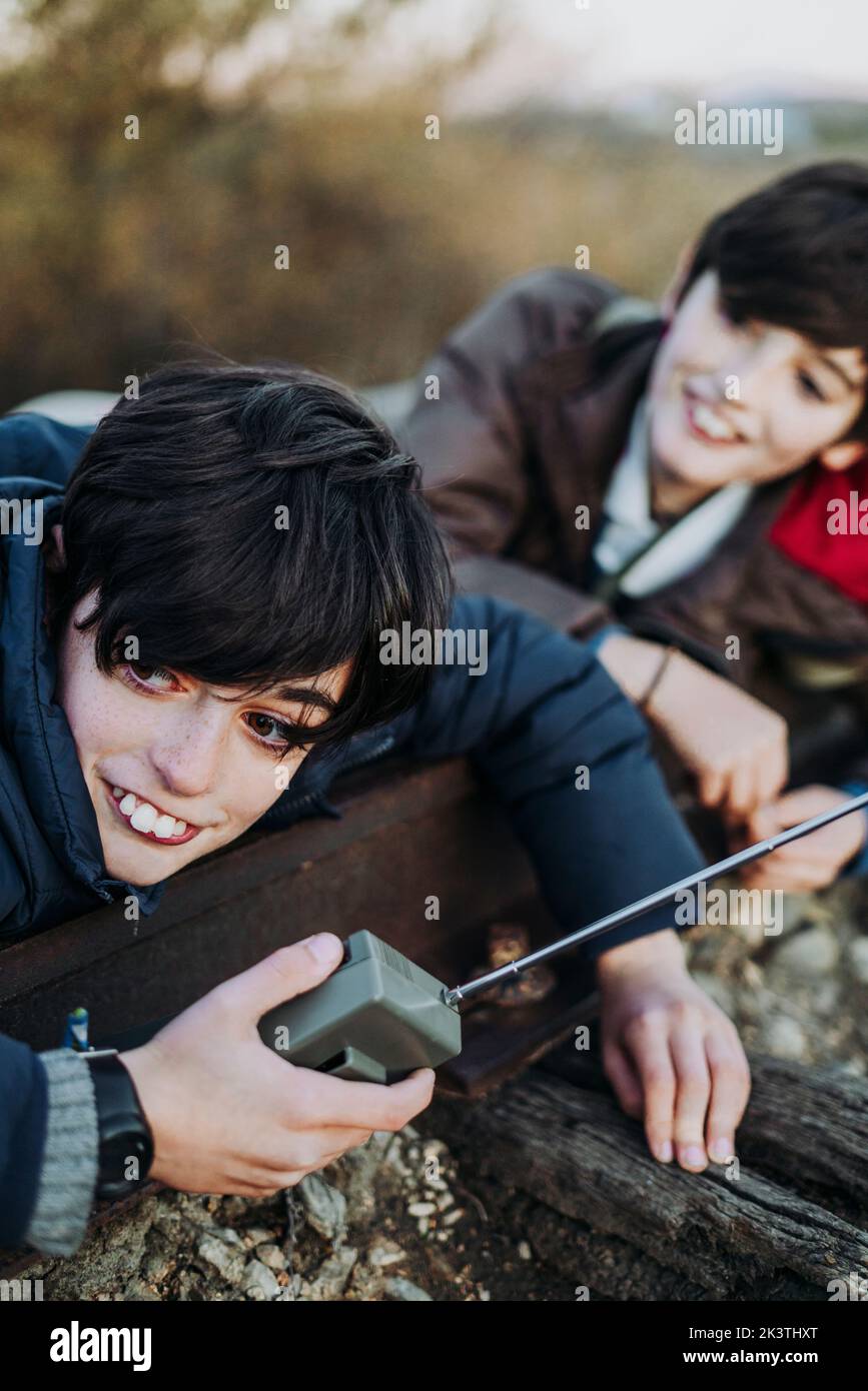 young children using a walkie-talkie lying on train tracks Stock Photo ...