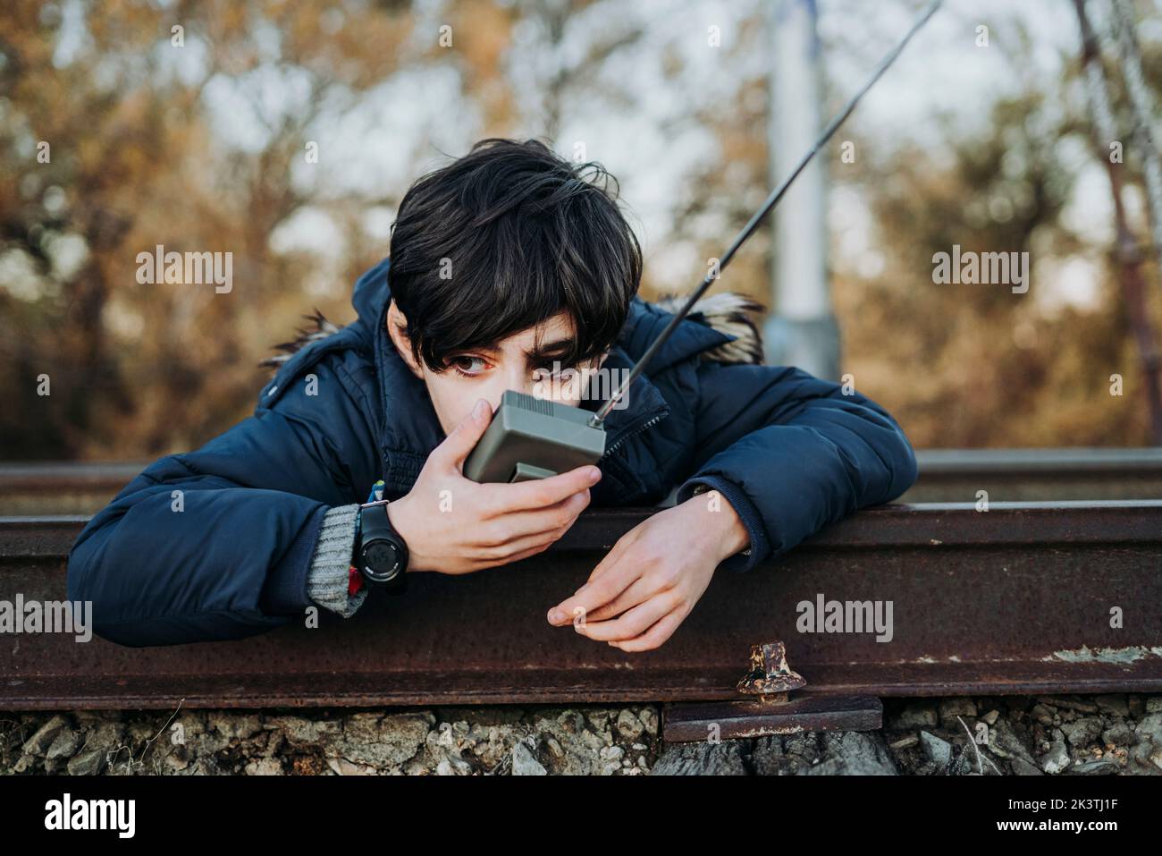 young child using a walkie-talkie lying on train tracks Stock Photo - Alamy
