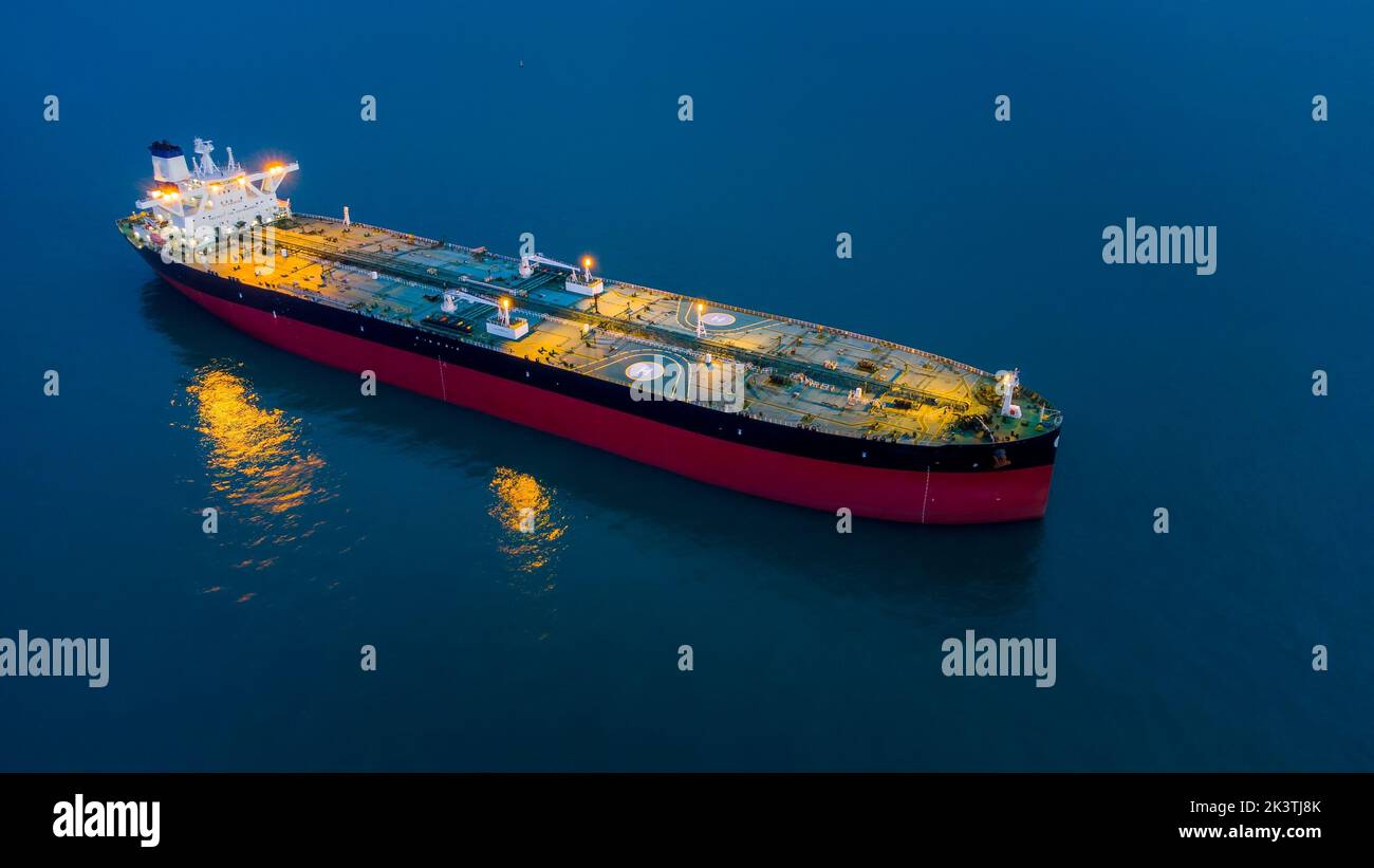 An oil tanker vessel at anchor during blue hour at the Singapore water ...