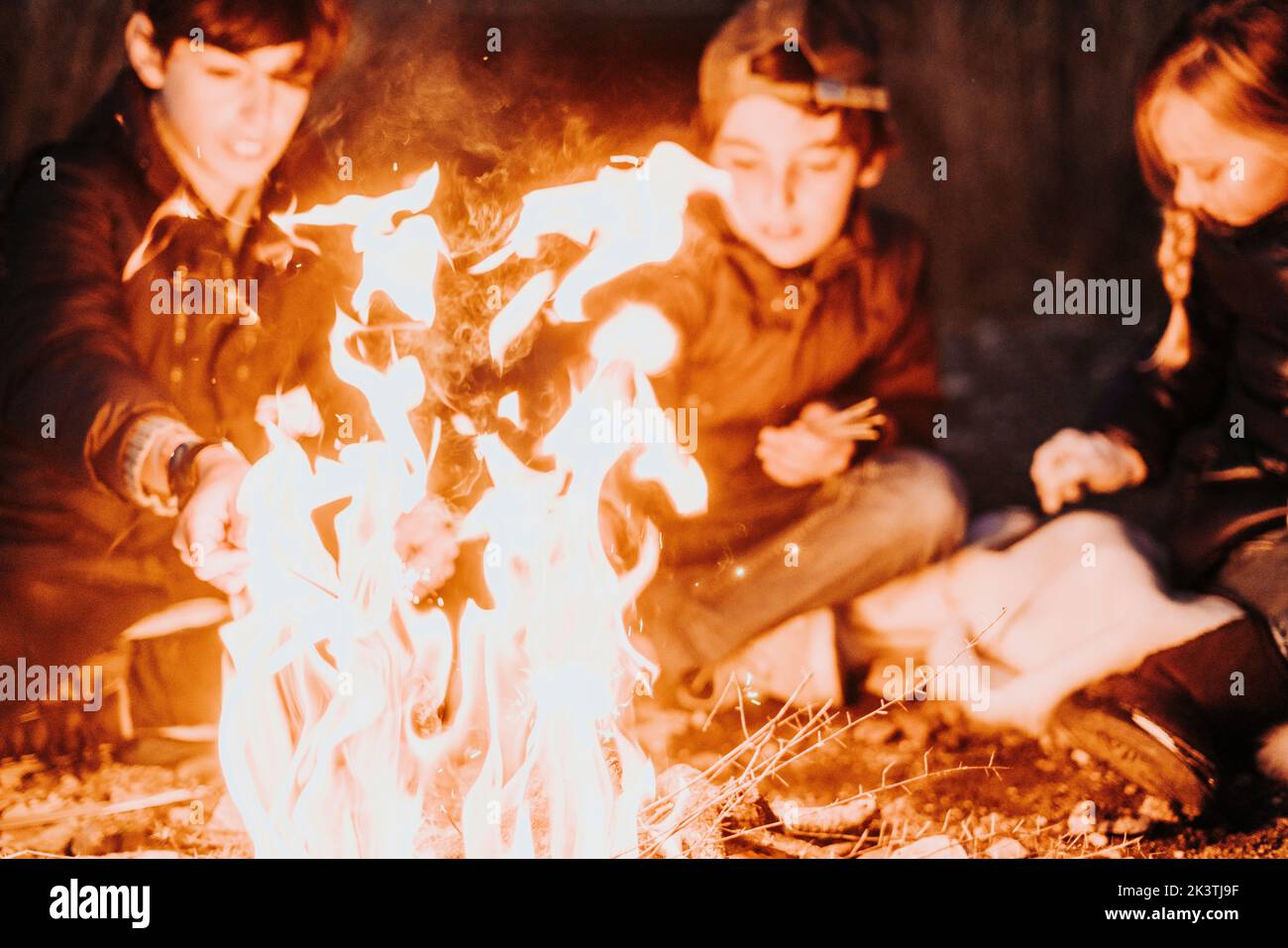 Group of young friends camping and burning a wood fire Stock Photo - Alamy