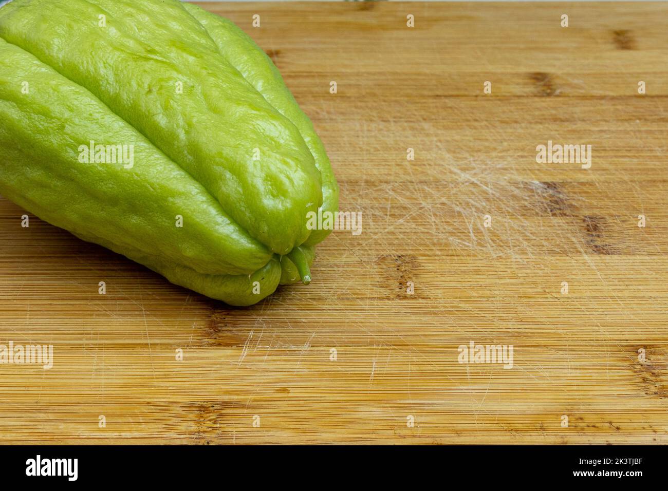 Partial view of a chayote on a wooden board, also known as: labu siam ...