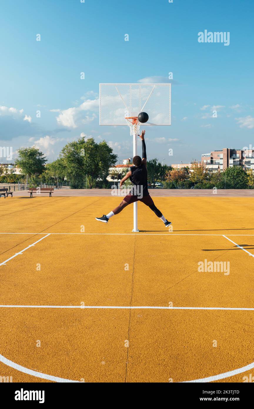 Back view of powerful energetic African American sportsman hanging on ...