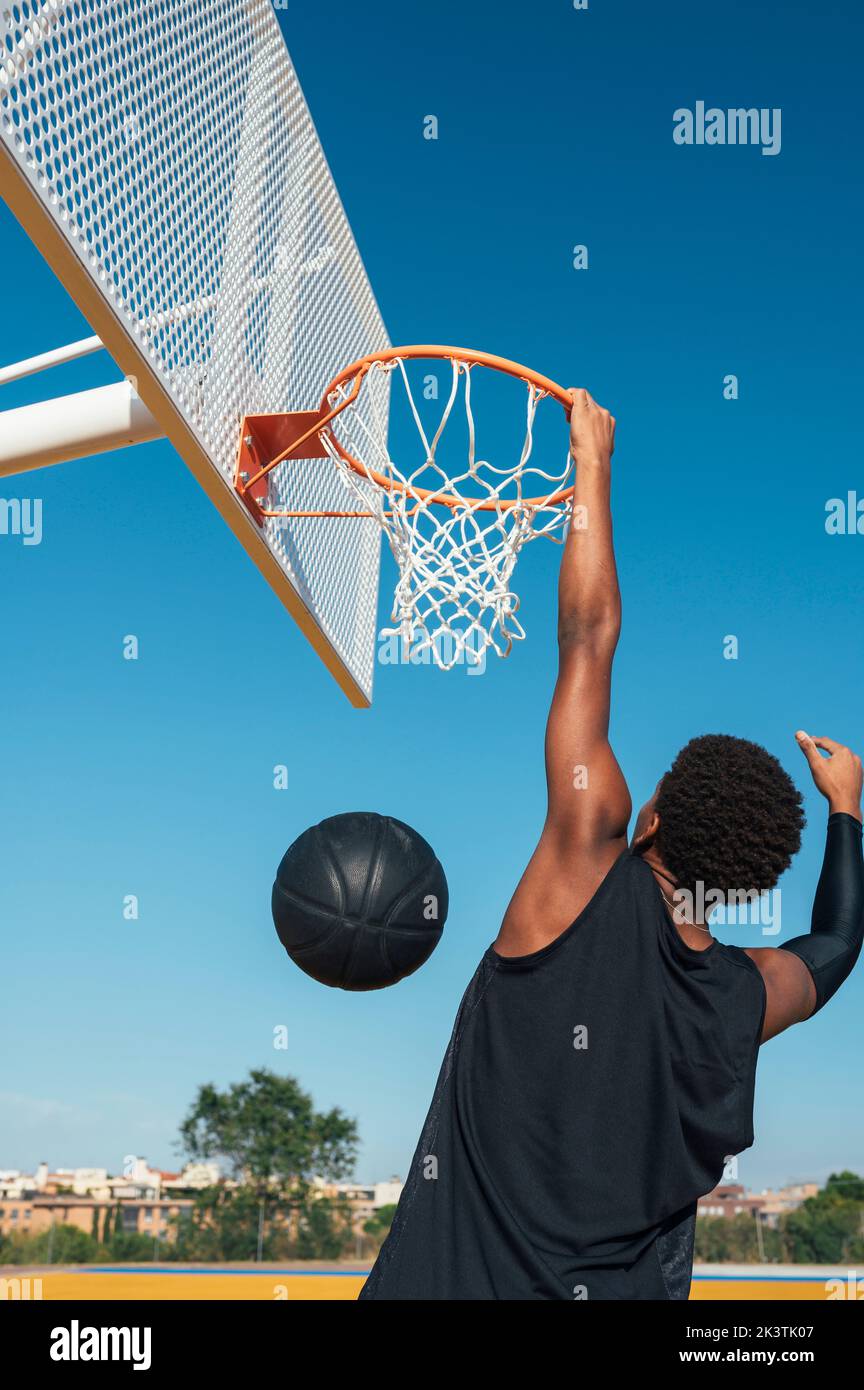 Back view of powerful energetic African American sportsman hanging on ...