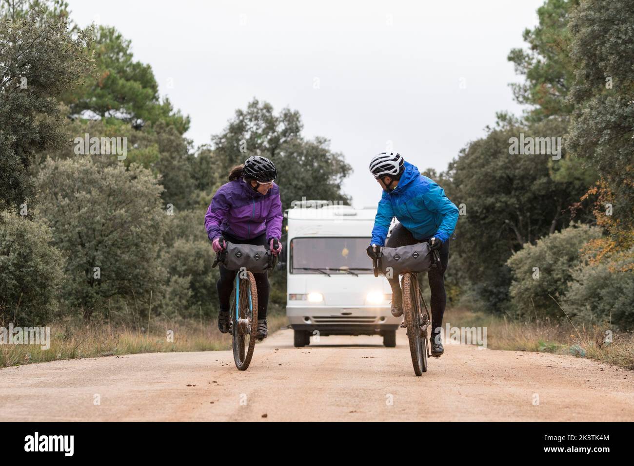 Couple in protective helmet and colorful jacket riding bikes after ...