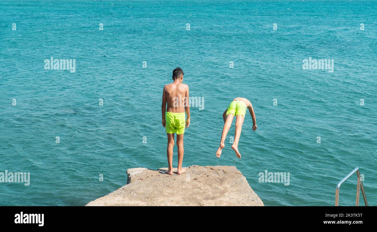 Children jumping into the sea hi-res stock photography and images - Alamy