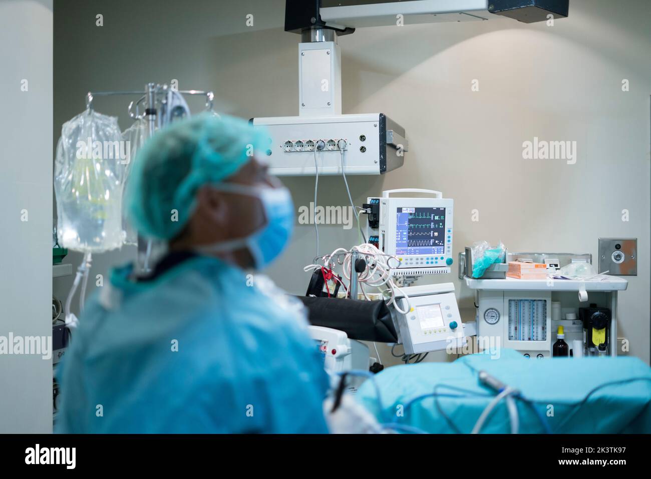 Blurred man in surgeon uniform looking away while conducting surgery in ...