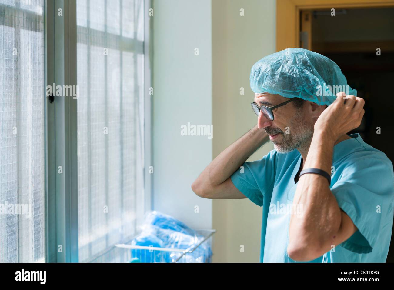 Surgeon putting on cap Stock Photo - Alamy