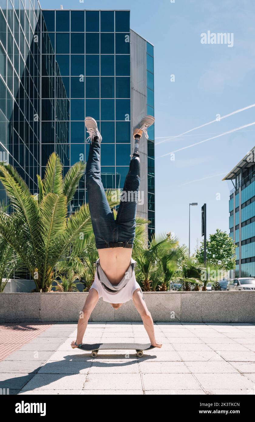 Sportive young man with artificial leg performing handstand on ...