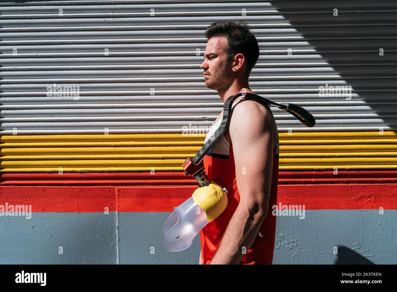 Side view of serious male athlete carrying artificial leg on shoulder ...