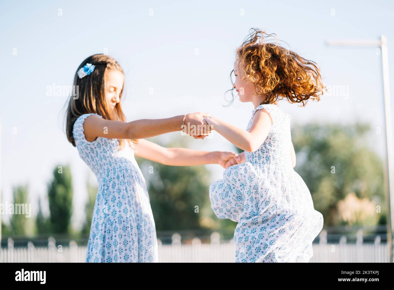 Sisters holding hands and spinning Stock Photo - Alamy