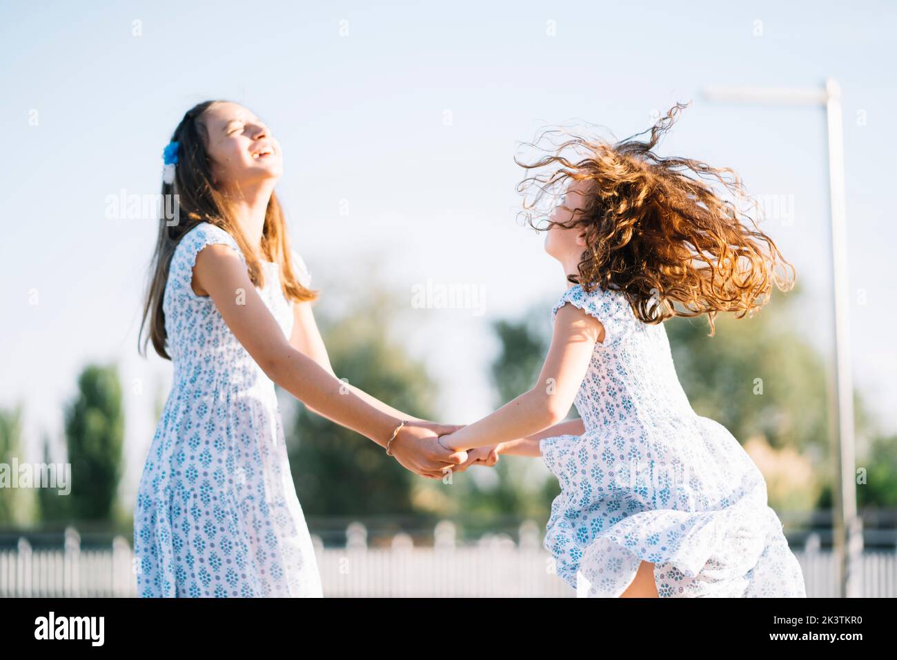 Sisters holding hands and spinning Stock Photo - Alamy