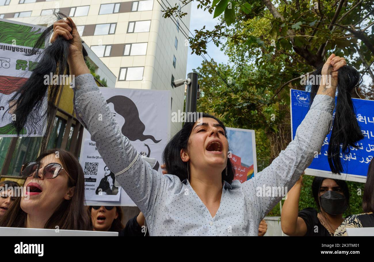 An Iranian female protester chants slogans as she holds pieces of her ...