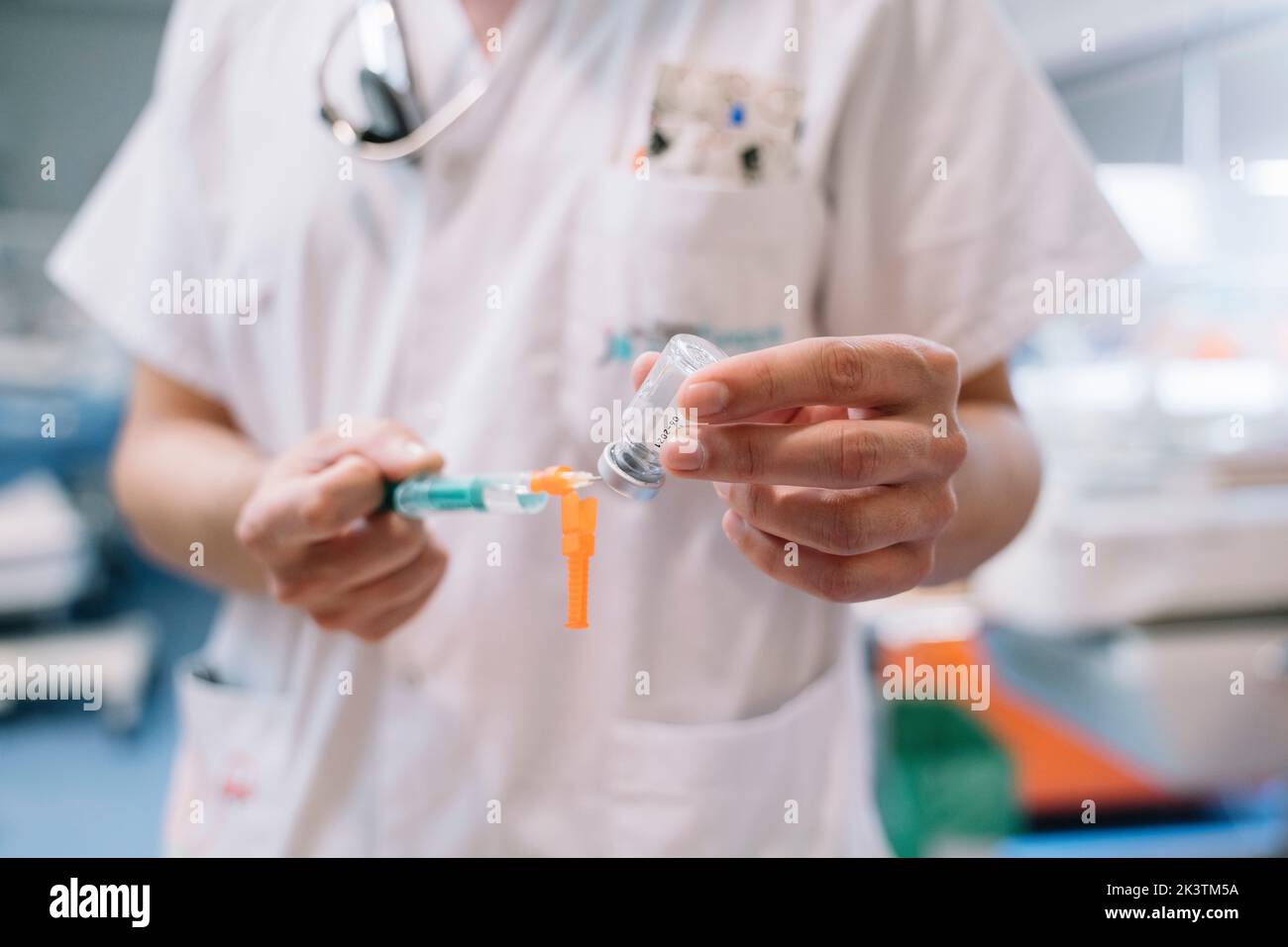 Soft focus hands unrecognizable doctor filling syringe with solution ...