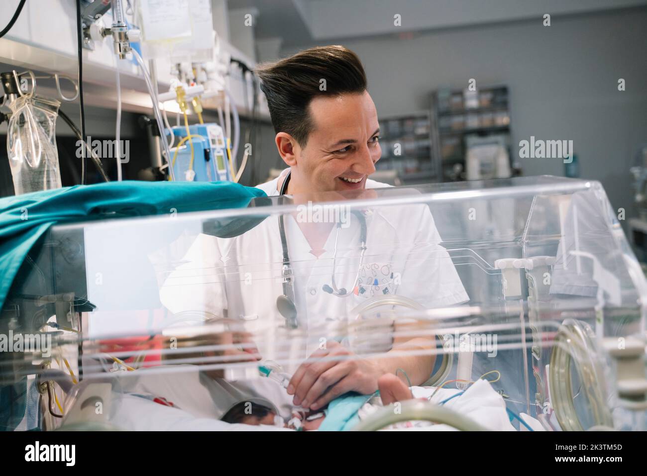 Doctor male attentively taking care of faceless newborn baby lying in ...