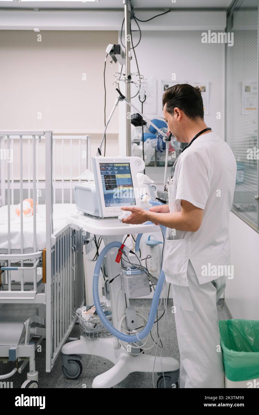 Back view of unrecognizable doctor male adjusting and controlling ...