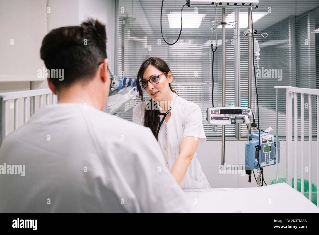 Doctors standing near hospital bed with newborn in intensive care unit ...