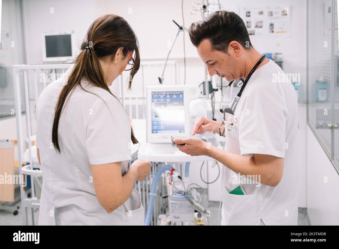 Back view of couple doctors adjusting and controlling parameters ...
