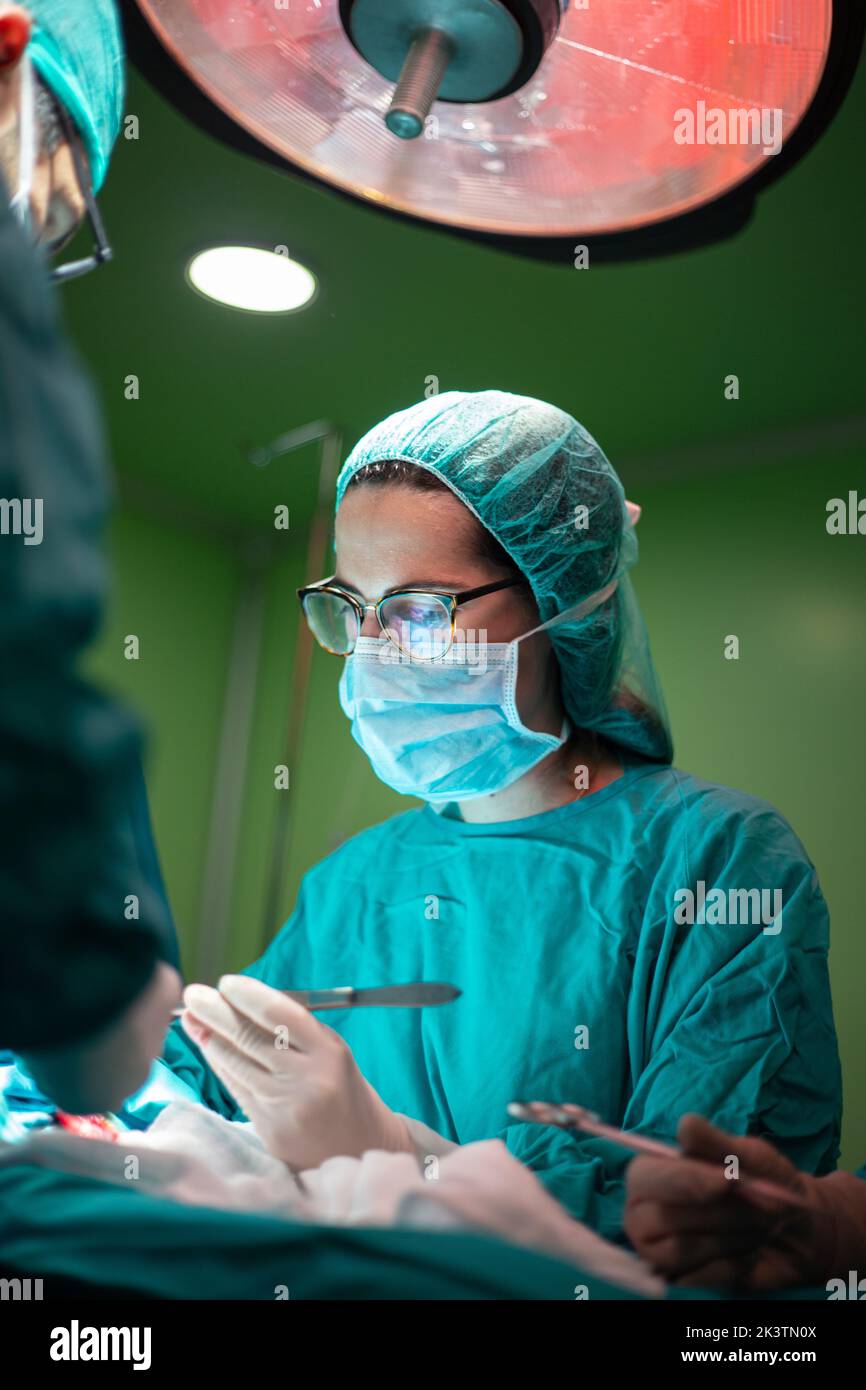 Female doctor in medical uniform performing surgery through cut on ...
