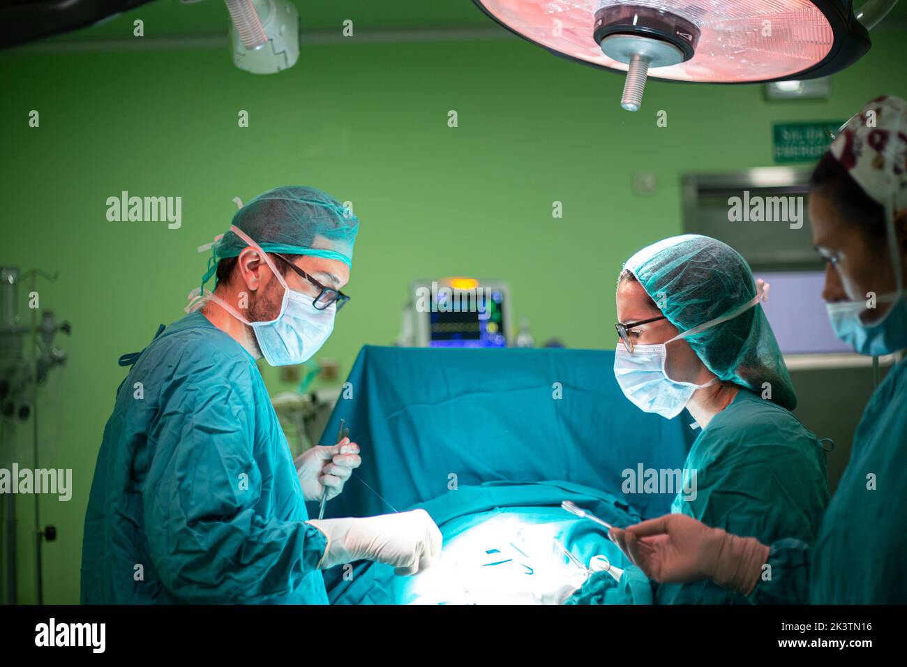 Side view of doctor and assistants in medical uniform performing ...