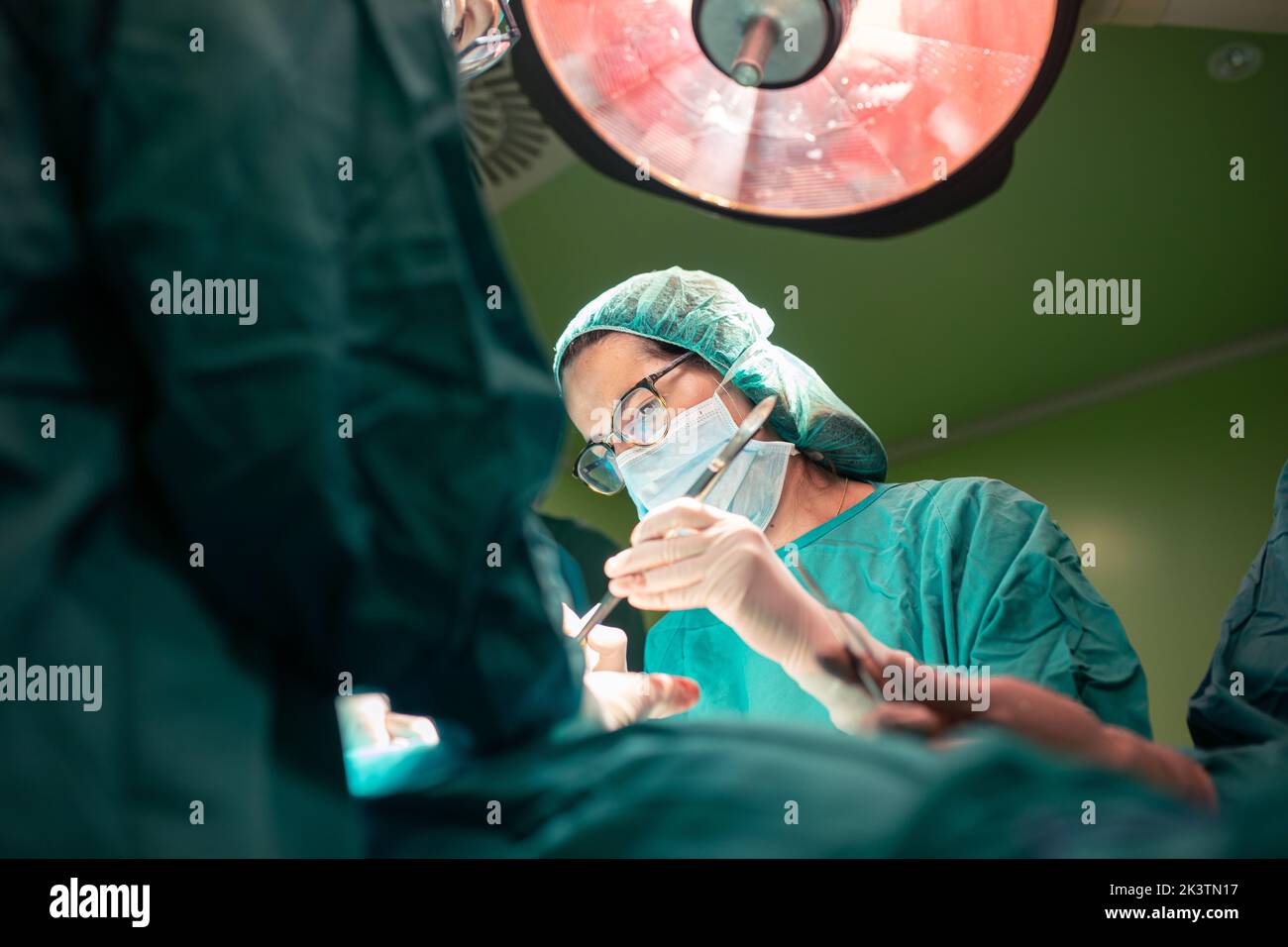 Female doctor in medical uniform performing surgery through cut on ...