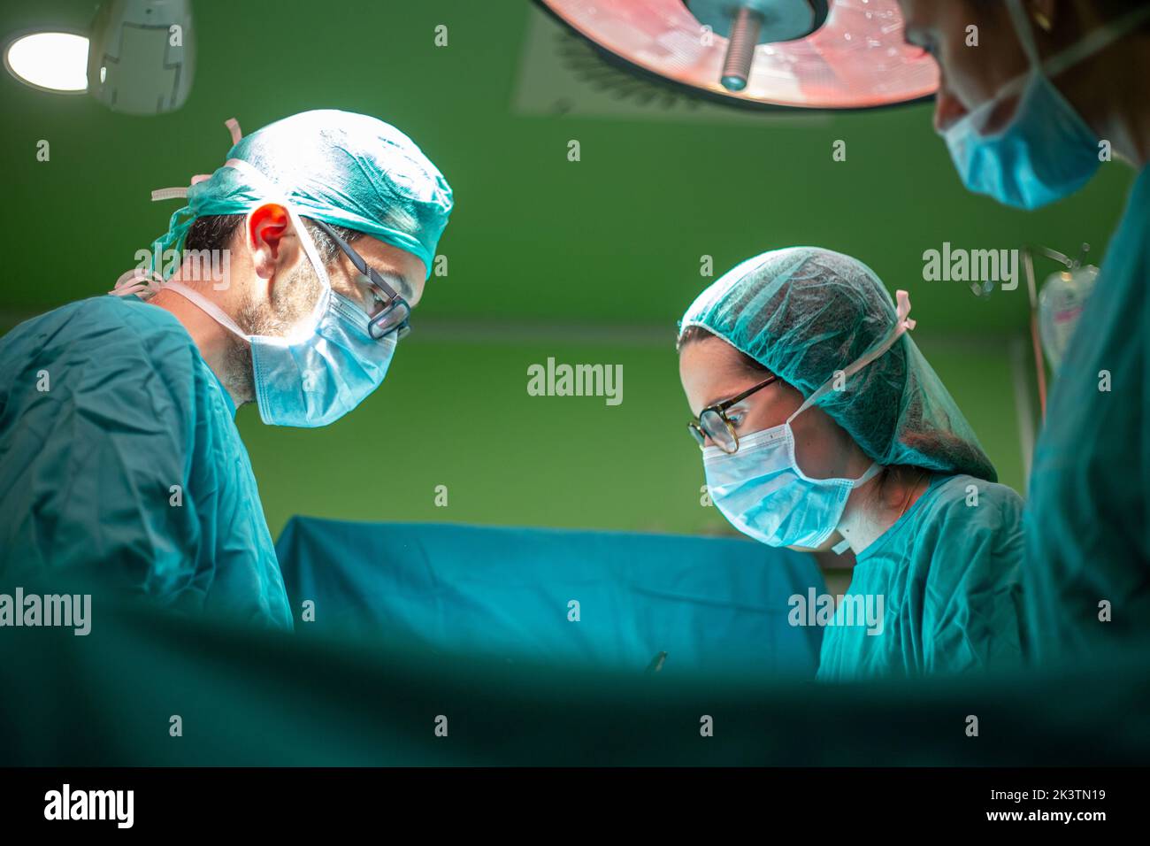 Side view of doctor and assistants in medical uniform performing ...