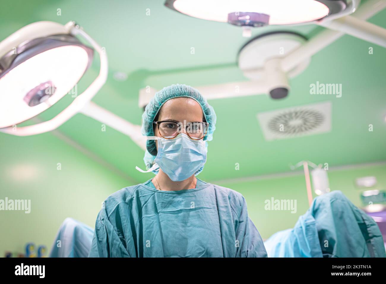 Female doctor in medical uniform performing surgery through cut on ...