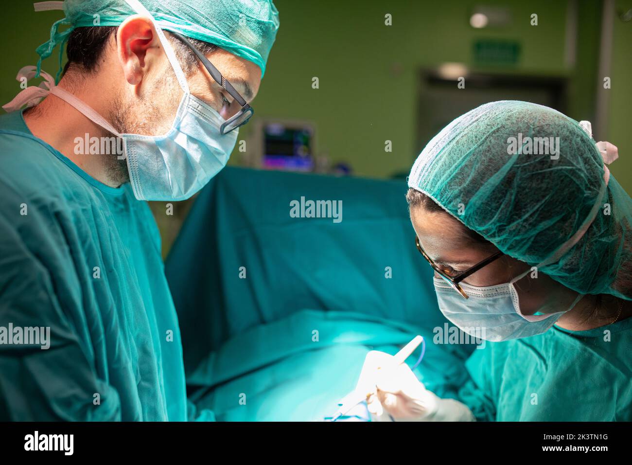 Side view of doctor and assistants in medical uniform performing ...