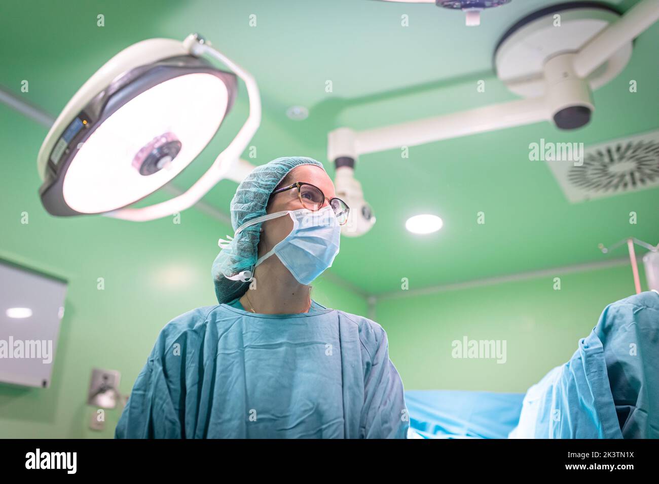 Female doctor in medical uniform performing surgery through cut on ...