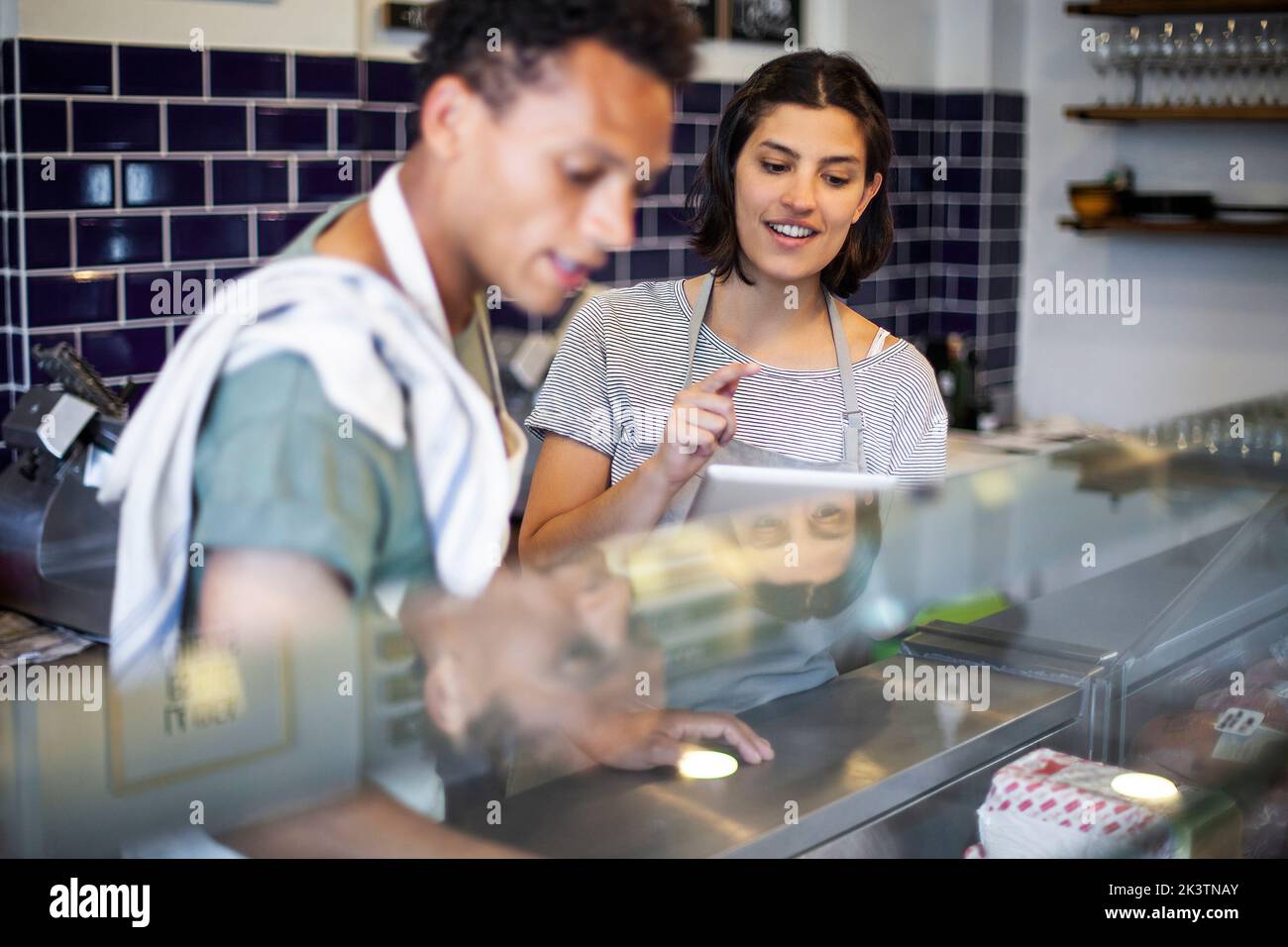 Grocery store coworkers discussing while looking at packaged food Stock ...