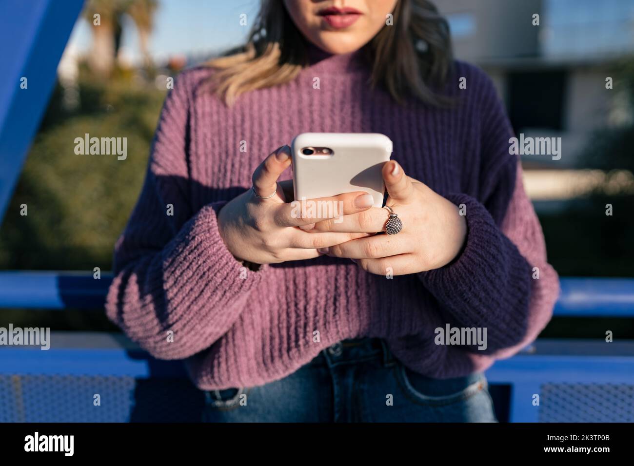 Anonymous female standing on bridge while surfing Internet on ...