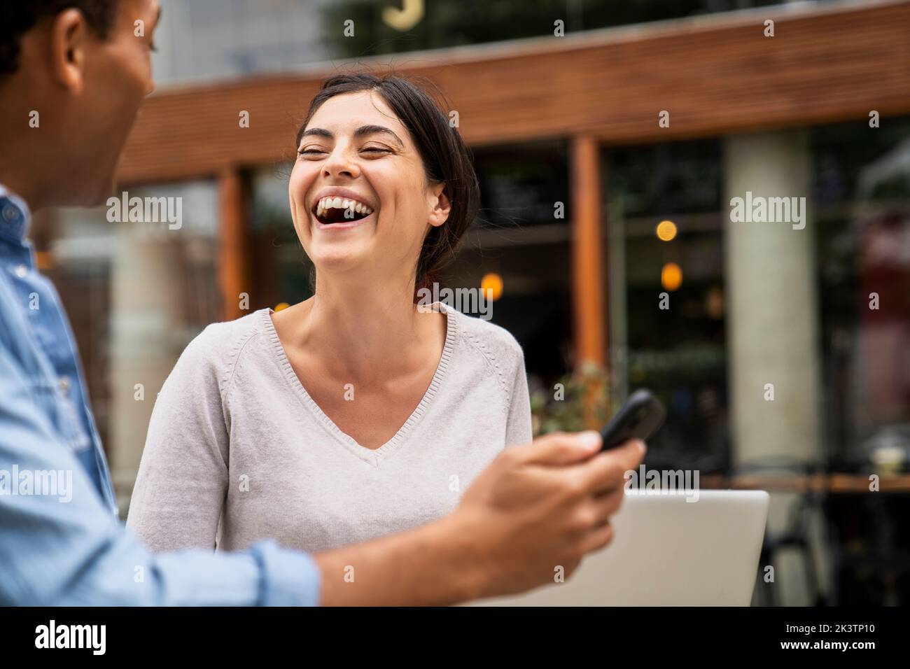 Side shot of diverse couple having a good time and laughing with their ...