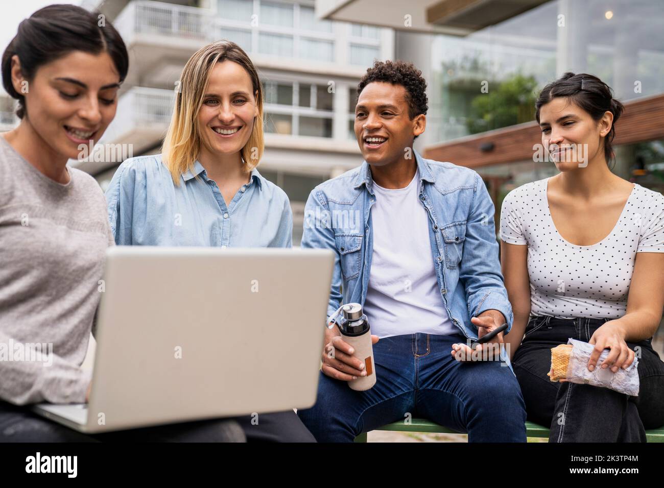 Diverse group of co-workers discussing work matters while working ...